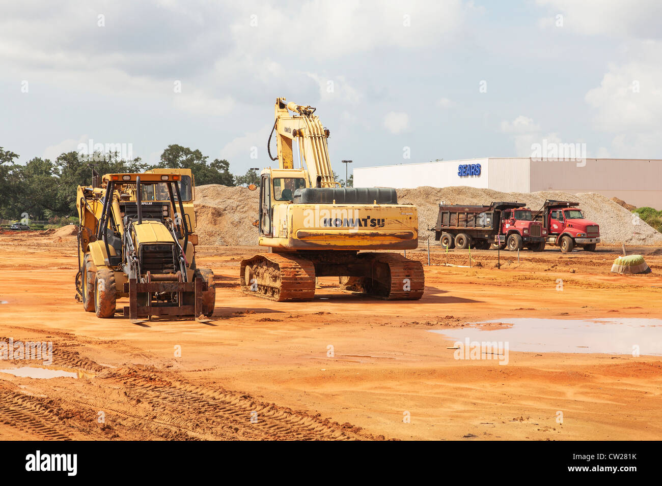 Track Hoe and Backhoe with dump trucks on Mall renovation site. Heavy ...