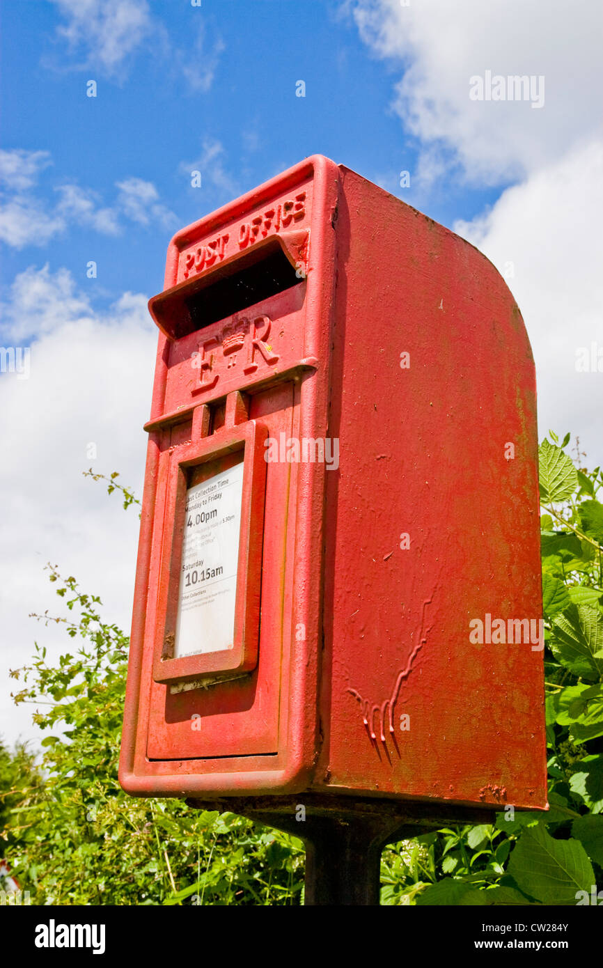 An old red small post box against a blue cloudy sky Stock Photo - Alamy