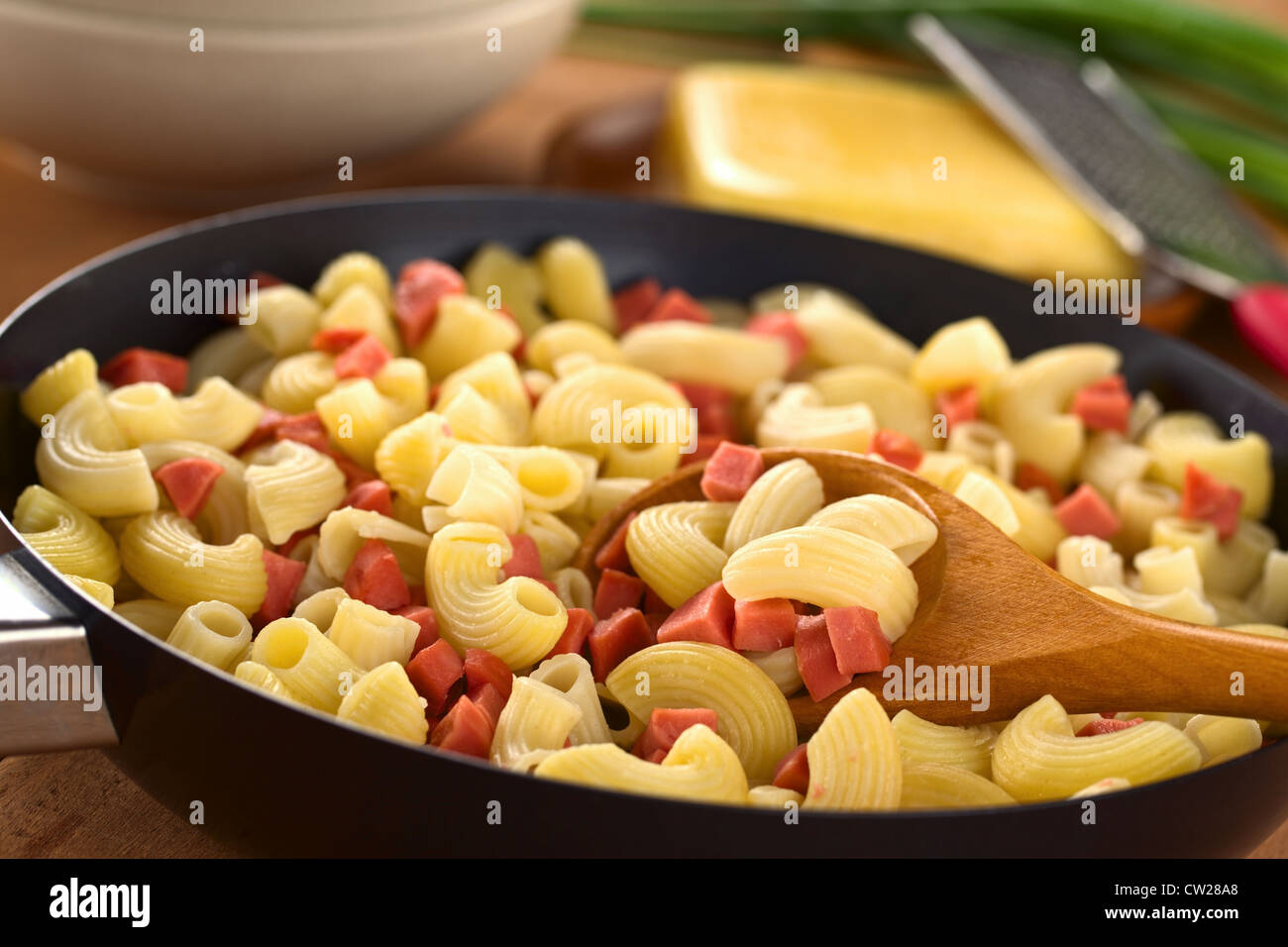 Preparing fresh homemade elbow macaroni pasta with sausage pieces in ...