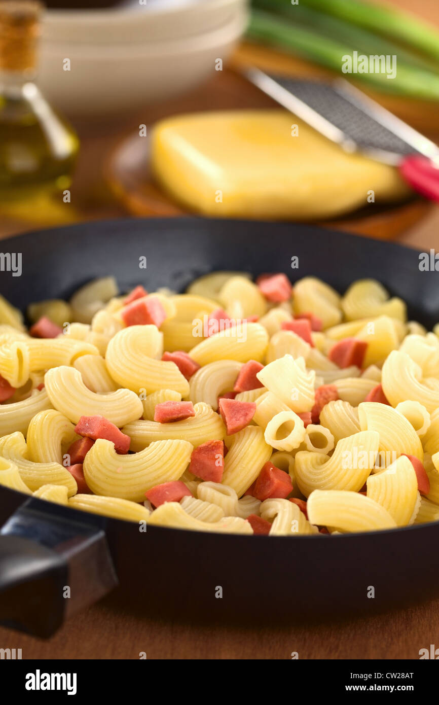 Preparing fresh homemade elbow macaroni pasta with sausage pieces in ...