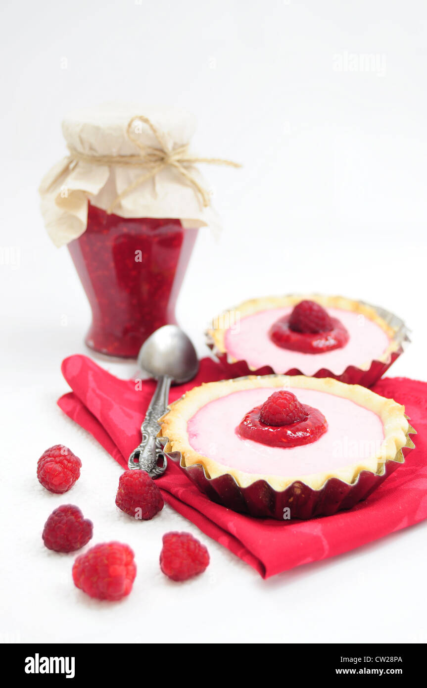 Two tarts with raspberry cream, jar of jam and raspberry fruits Stock ...