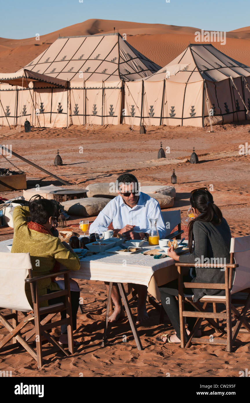 tourists enjoy breakfast at a luxury desert camp in the Sahara at Erg ...
