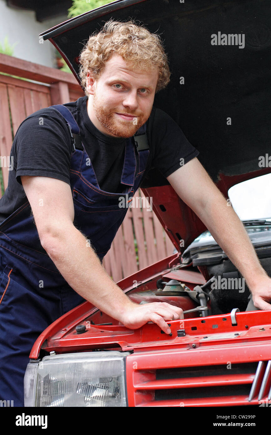 A young mechanic repairing the old car, portrait Stock Photo - Alamy