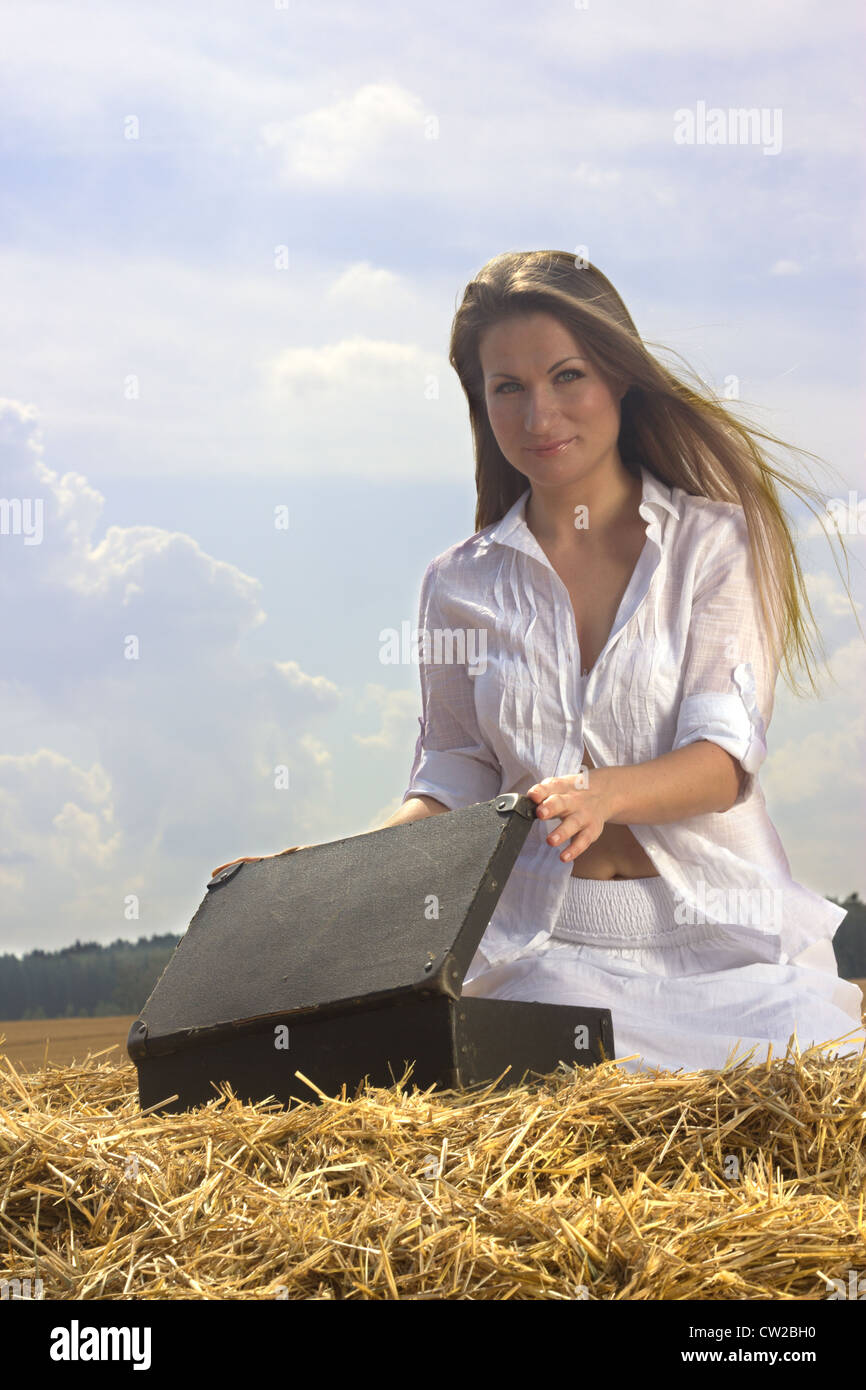 Beautiful woman with a box on hay stack Stock Photo - Alamy