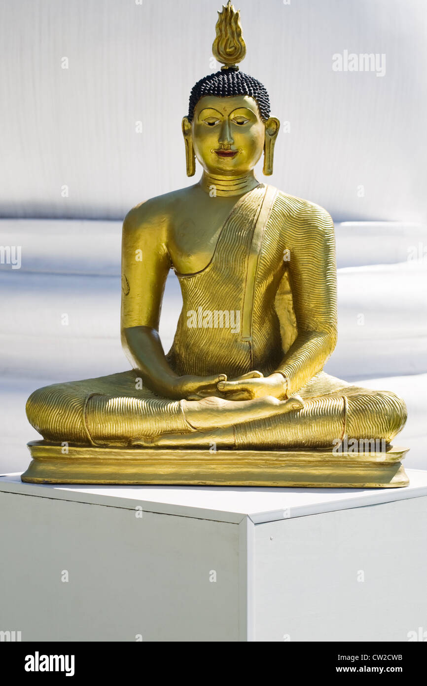 Golden statue of seated Buddha in lotus position Stock Photo - Alamy