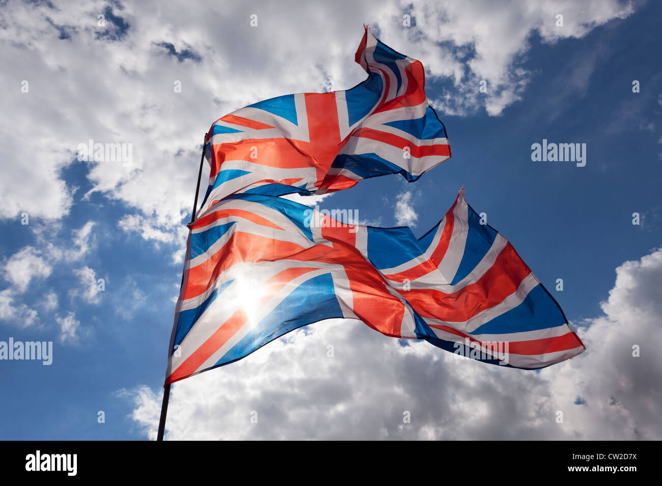 Union jack flag flying against a blue sky with some cumulus clouds. The ...