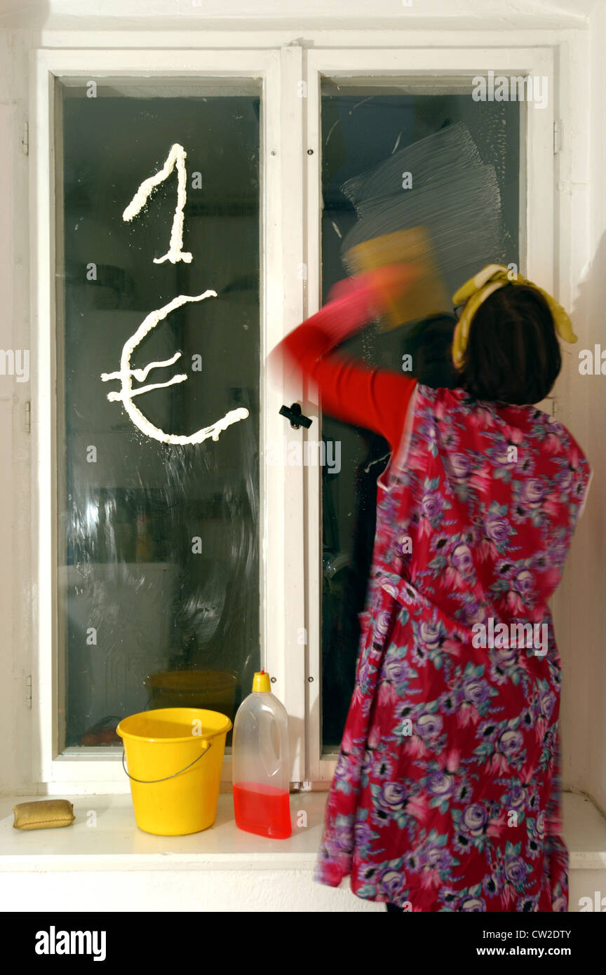 Woman dressing windows with 1 euro symbol Stock Photo - Alamy