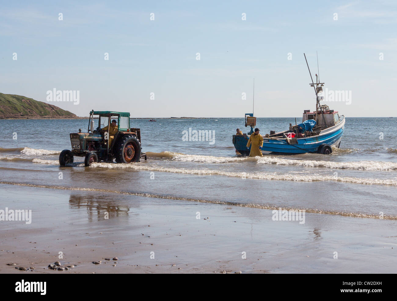 Filey Sands Yorkshire UK.Tractor pulling fishing coble ashore Stock ...