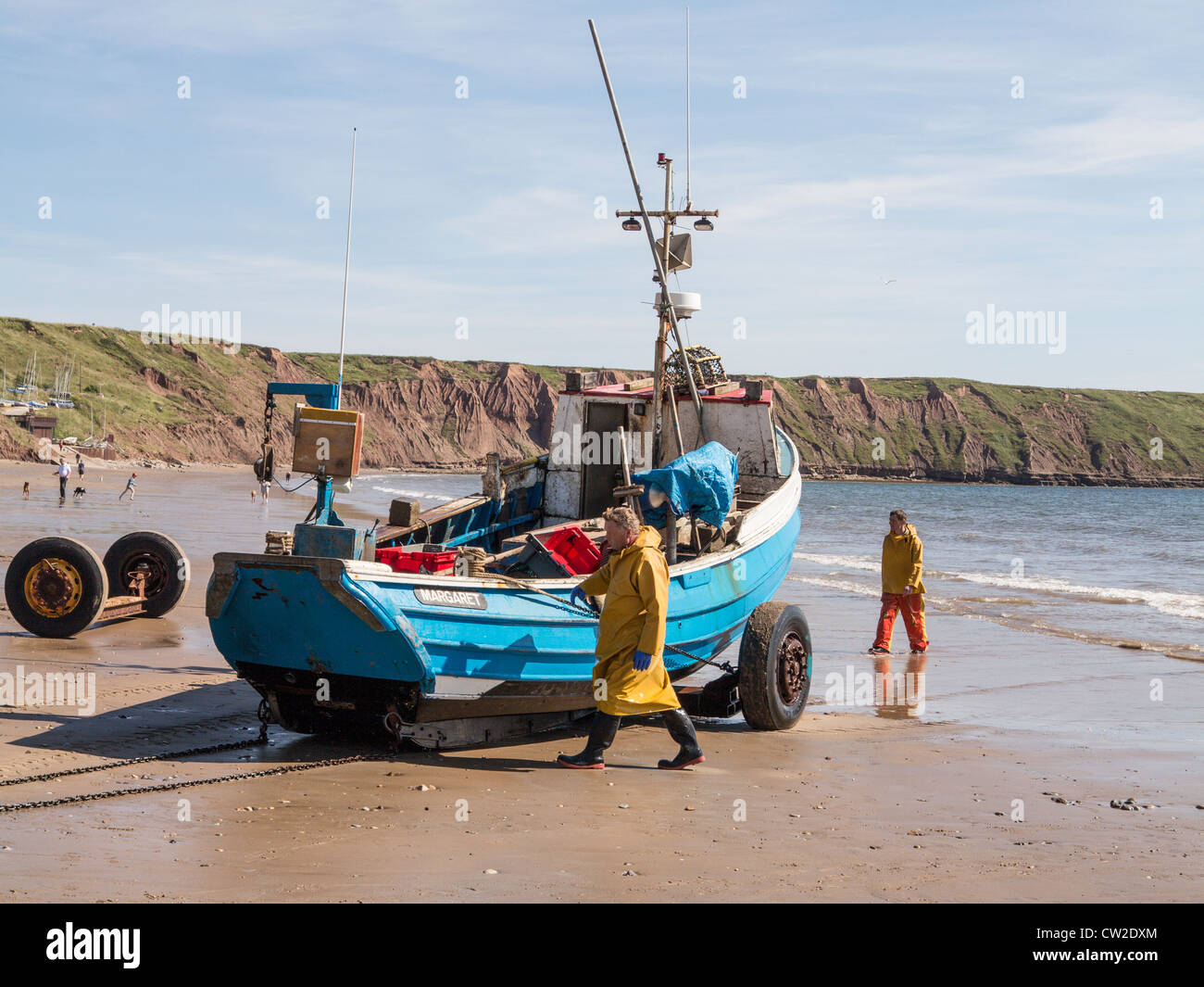 Filey Sands Yorkshire UK. Fishing Coble and fishermen on the Sands ...
