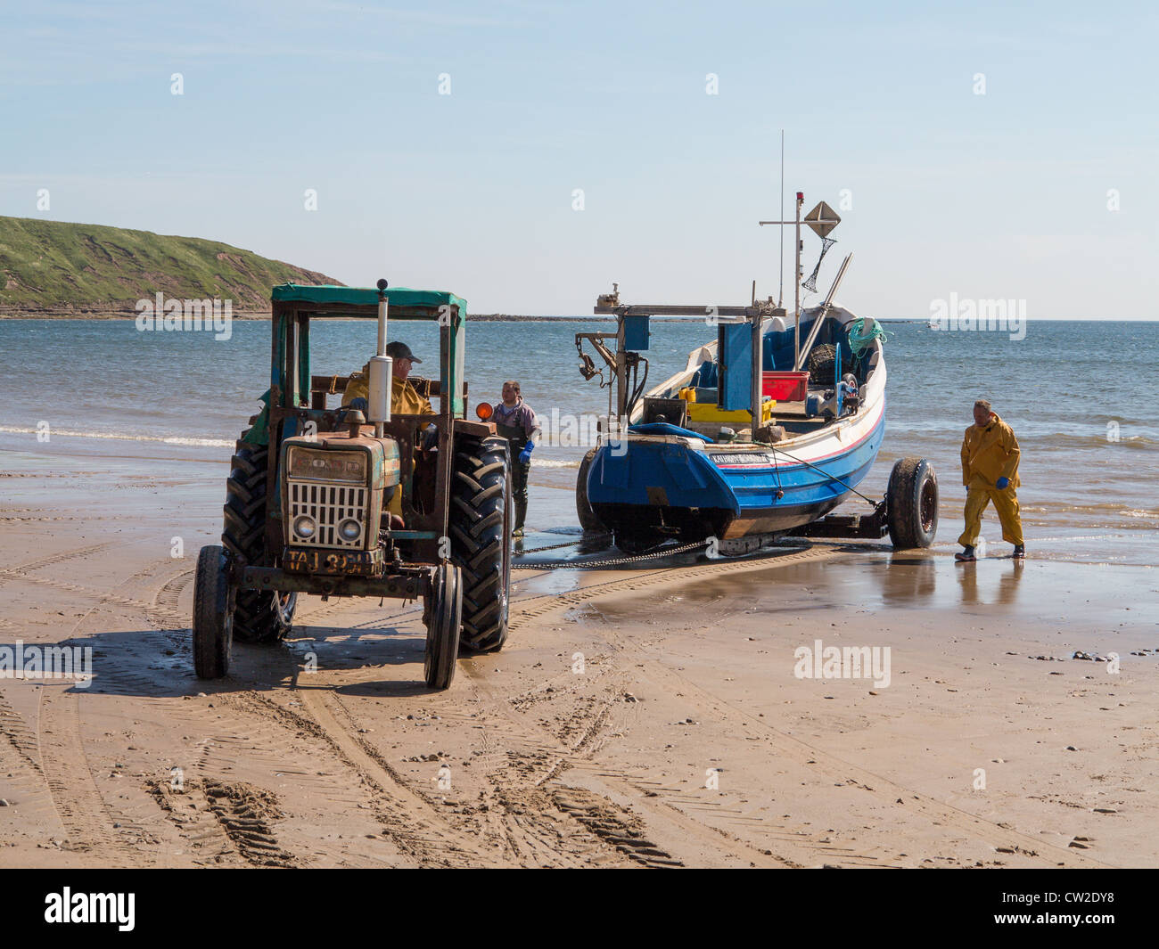 Filey Sands Yorkshire UK.Tractor pulling fishing coble ashore Stock ...