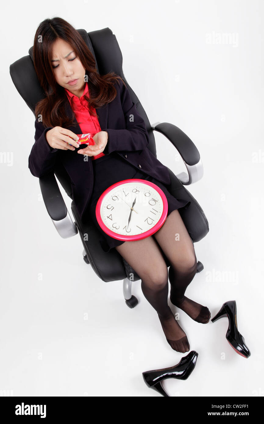 Office lady is tired of working and eating candy Stock Photo - Alamy