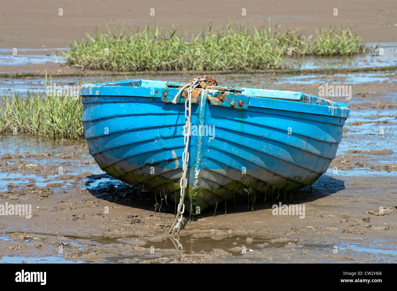 Old blue wooden rowing boat beached by the ebb tide in Morecambe Bay ...