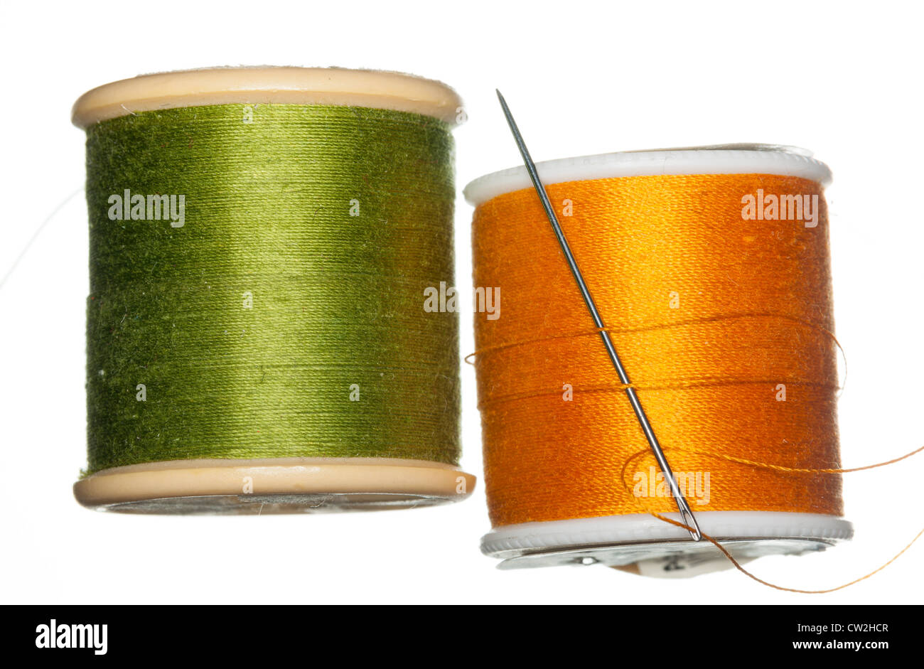 Green and Orange cotton thread on bobbins isolated against white Stock ...