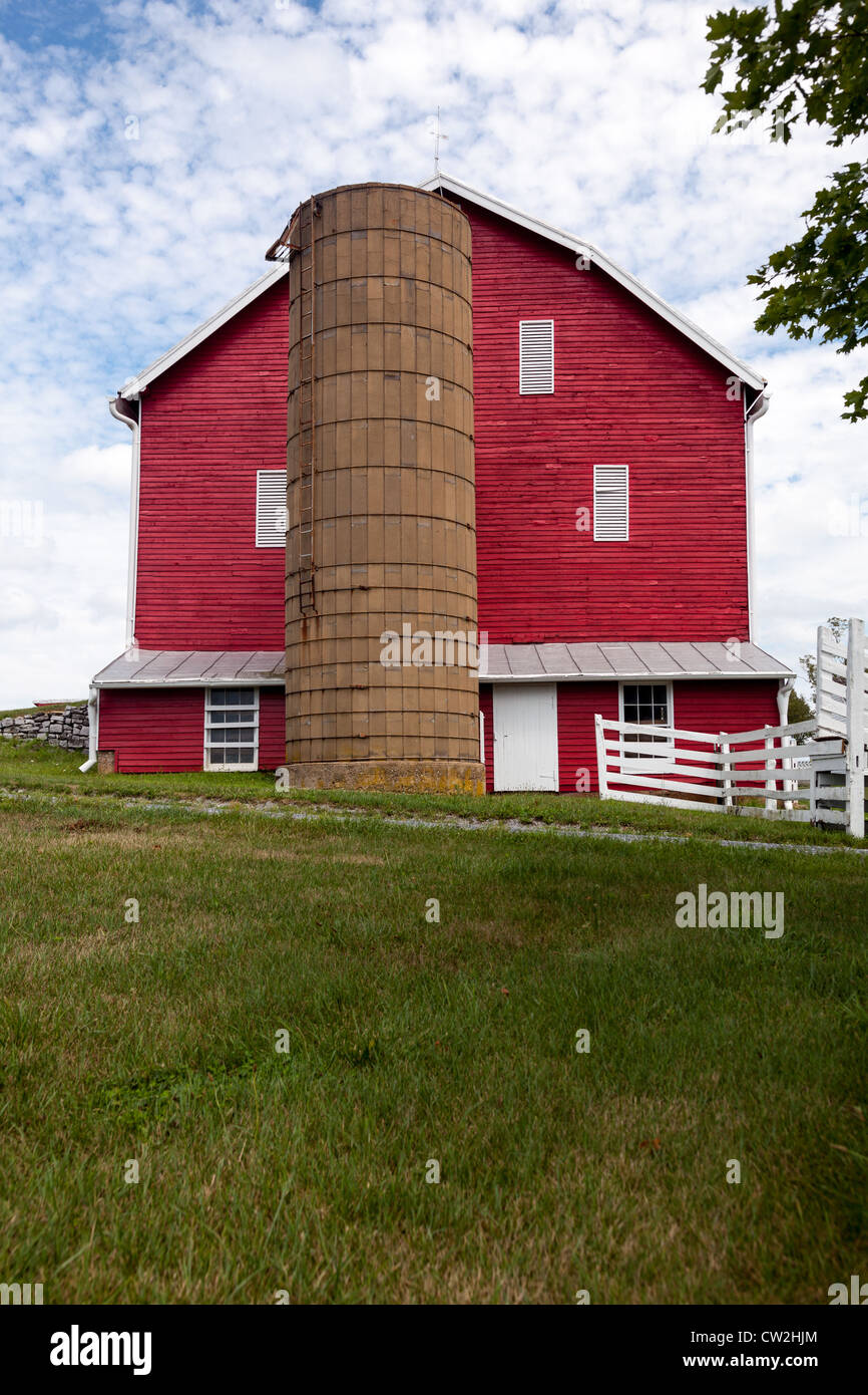 Red painted wooden barn with white door on farm in traditional US style ...