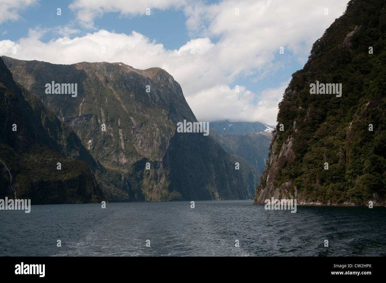 Steep mountain slopes dip into Milford Sound, an important touristic ...