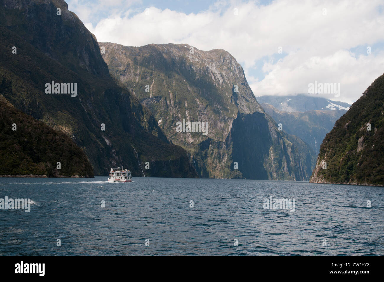 Steep mountain slopes dip into Milford Sound, an important touristic ...
