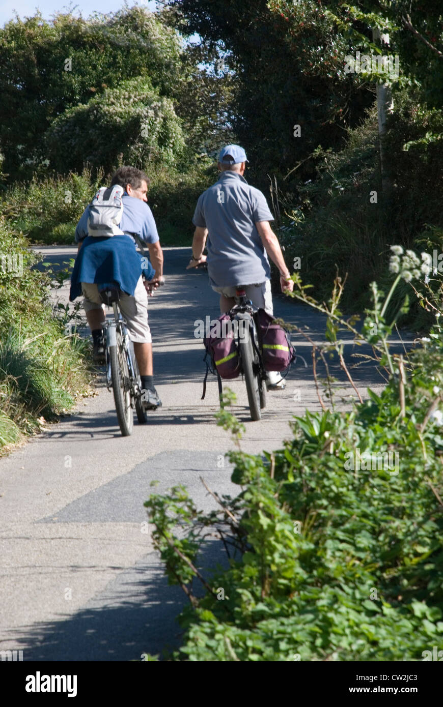 Two friends enjoying a cycle ride along a quiet Cornish lane Stock ...