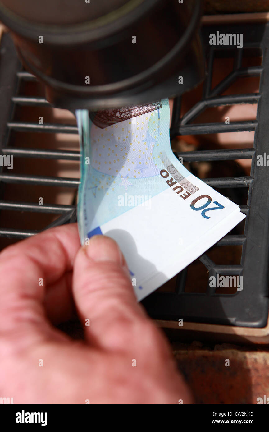 A hand pulling euro notes out of a drainpipe Stock Photo - Alamy