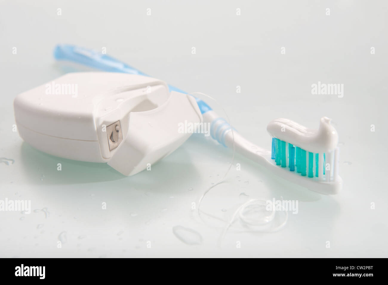 Toothbrush with toothpaste and dental floss on light background Stock ...