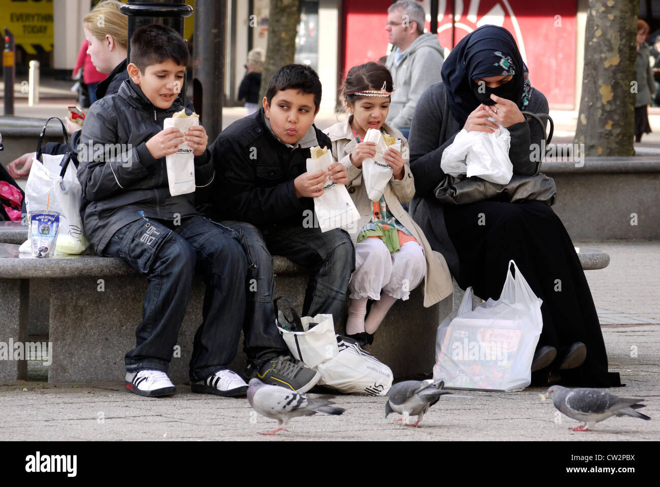 Asian family eating pasties on Victoria Square precinct in Bolton ...