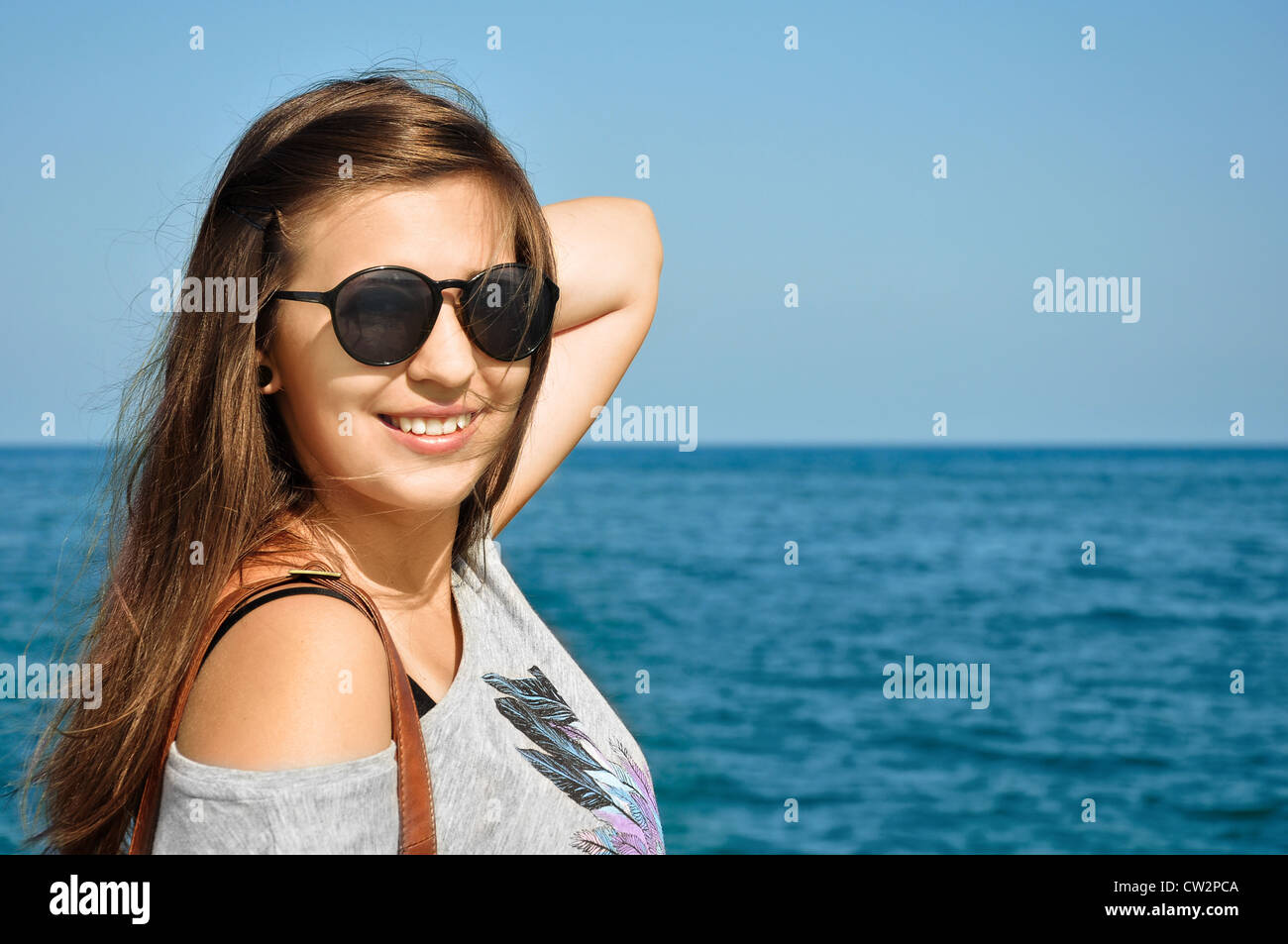 Pretty young female with sunglasses on at the beach Stock Photo - Alamy