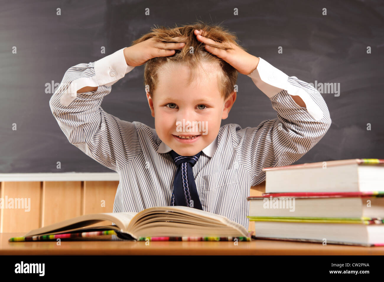 Cute elementary aged boy fooling at the lesson Stock Photo - Alamy