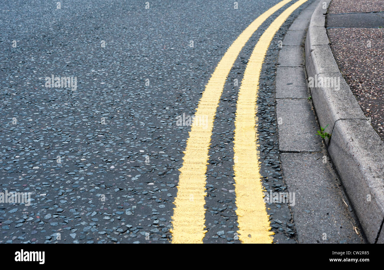 Double yellow lines on a road close up Stock Photo - Alamy