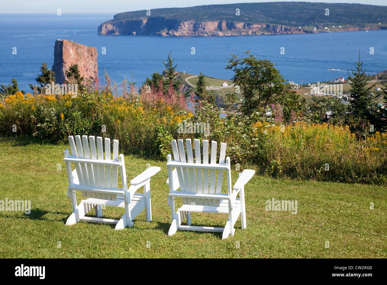 A high overlook with too Adirondack chairs considering a view of Perce ...