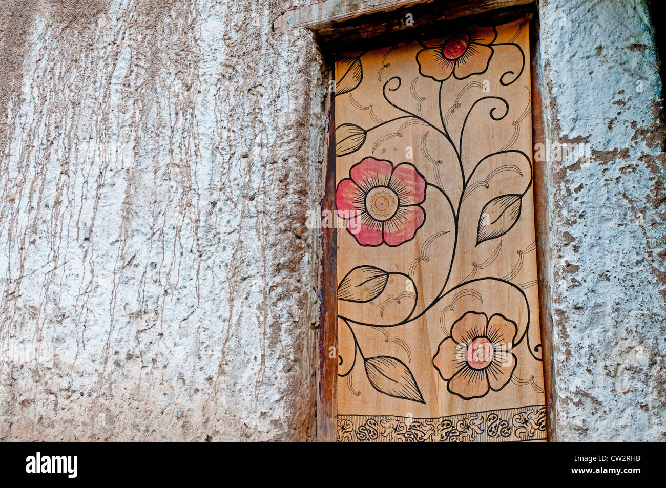 A flower print curtain covering a doorway in a white-washed stucco wall ...
