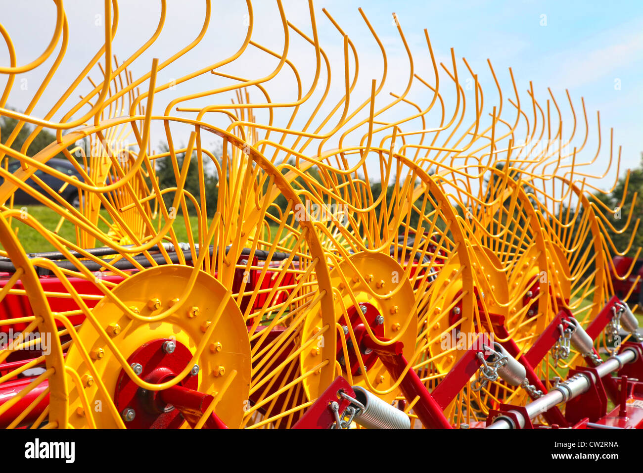 A vividly painted brand new hay rake Stock Photo - Alamy