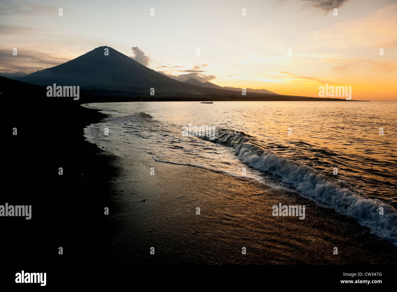 The volcanic black sand beach with the volcano Gunung Agung in the ...