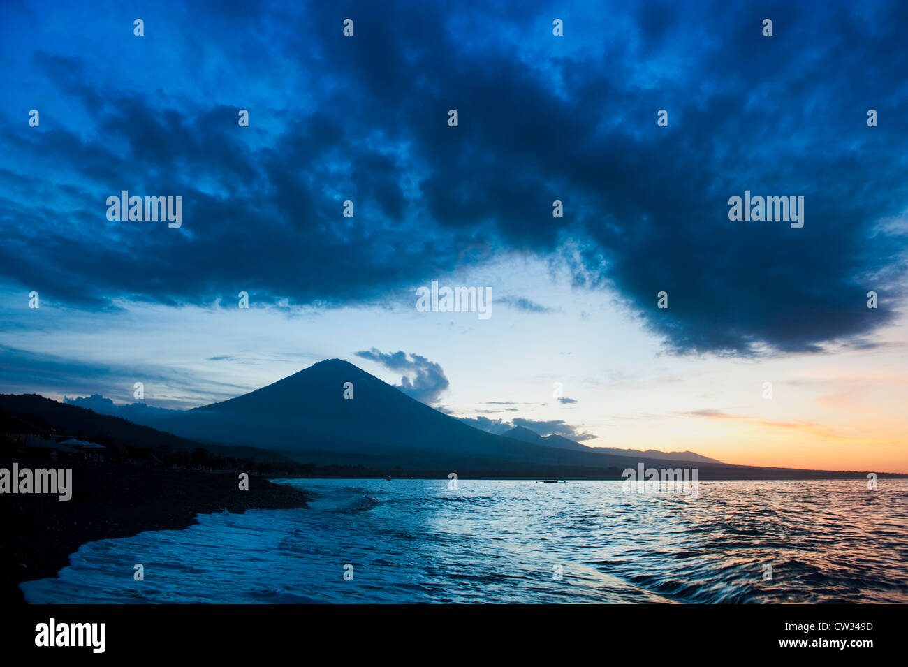The volcanic black sand beach with the volcano Gunung Agung in the ...