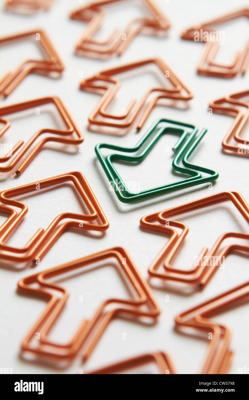 Green Arrow Going Against The Flow Of Orange Arrows Stock Photo - Alamy