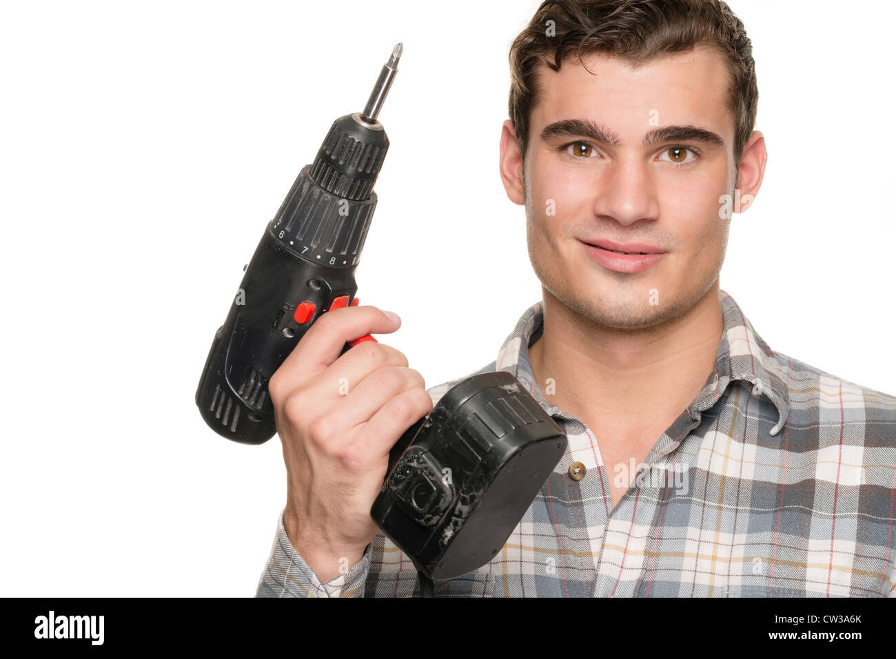 Smiling young man with drill machine in front of white background Stock ...