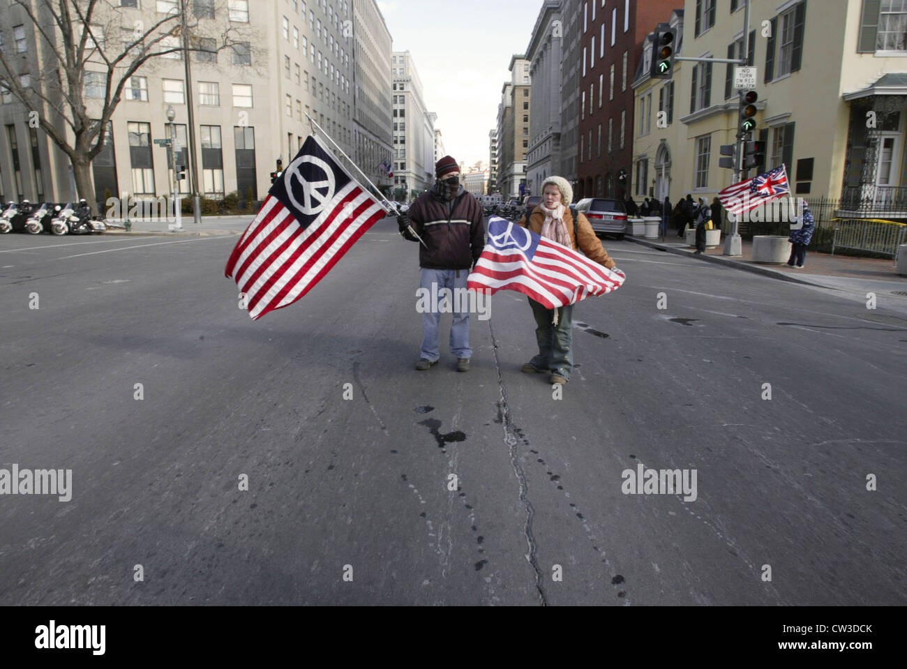 Protesters hold up flags with peace signs in the street outside of ...