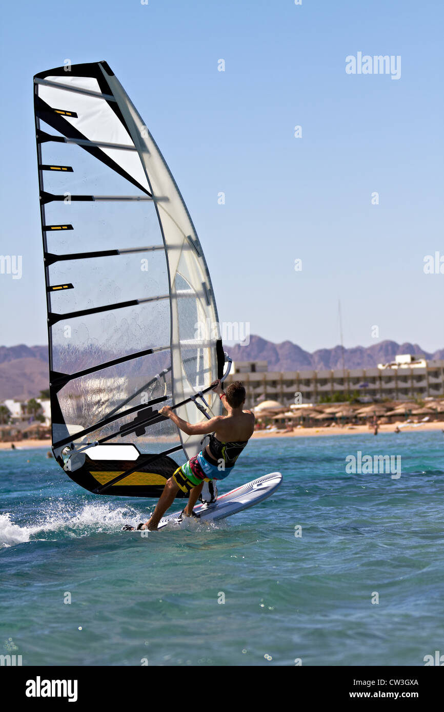 Rear view of a windsurfer passing by Stock Photo - Alamy