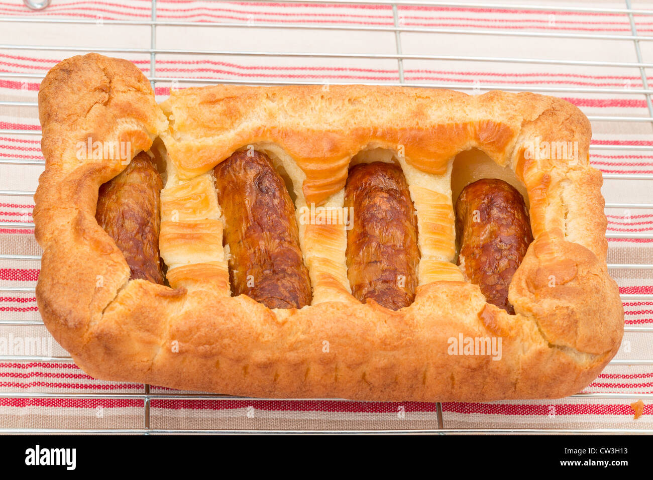 A classic British dish of Toad in the Hole, which is pork sausages ...
