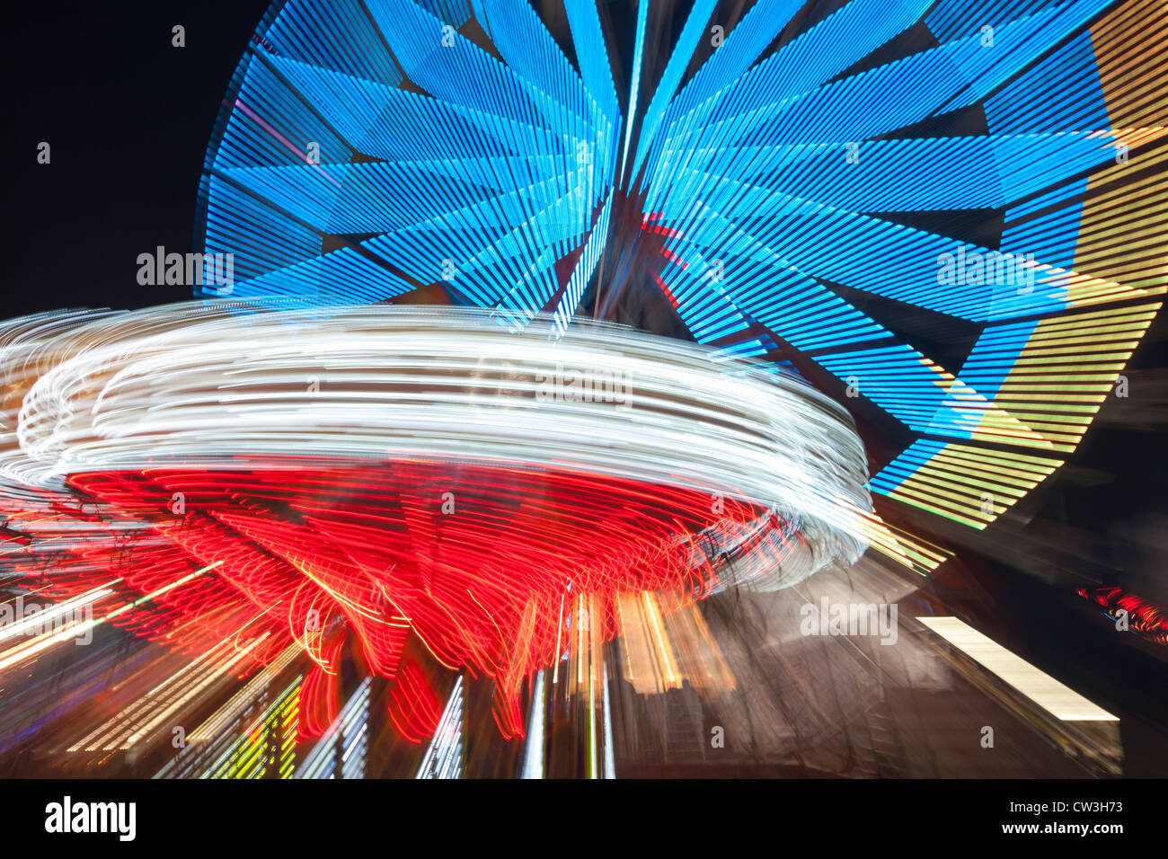 Colorfully illuminated rides spin against the night sky during the New ...