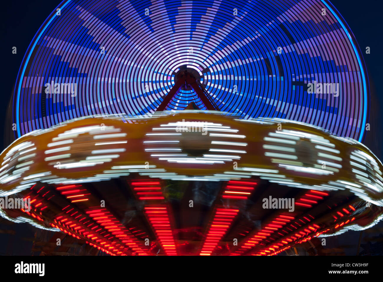 Colorfully illuminated rides spin against the night sky during the New ...