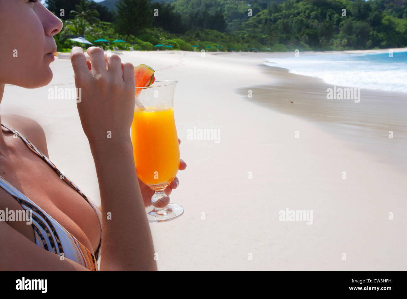Woman in swimming costume drinking a cocktail on beach.Seychelles Stock ...