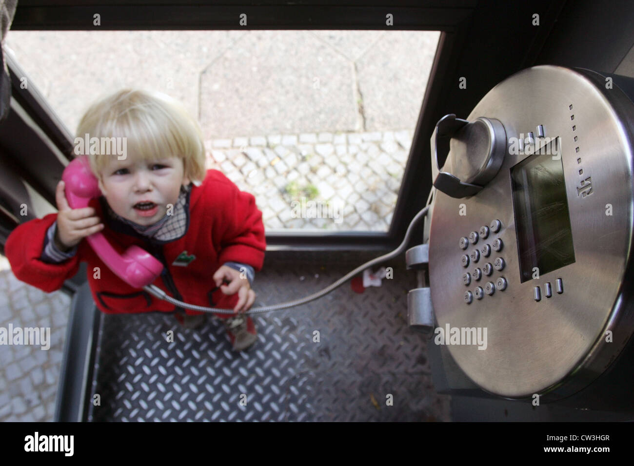 Berlin, a toddler on the phone in a phone booth Stock Photo - Alamy