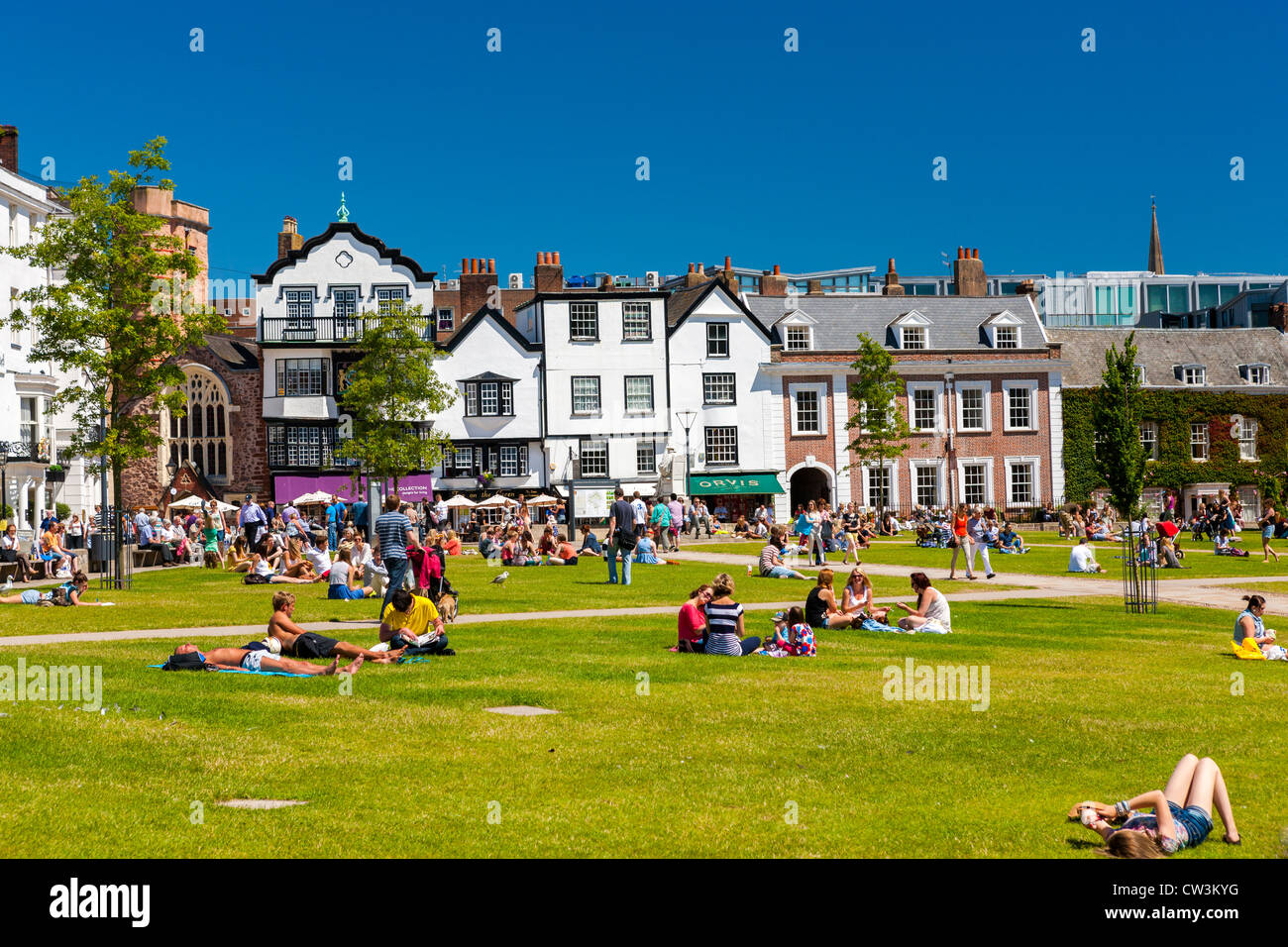 People relaxing on grass at Cathedral Close, Exeter, Devon, England ...