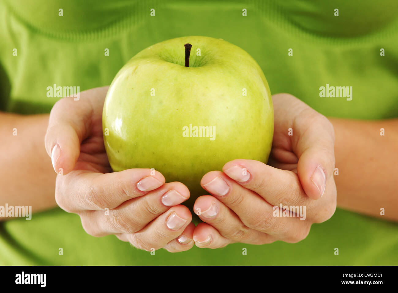green apple in woman hands Stock Photo - Alamy