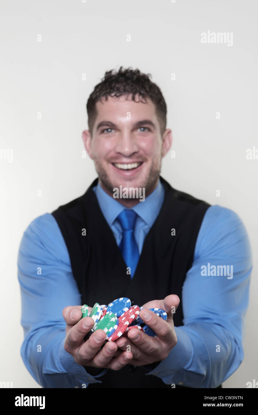handsome man holding a lot of poker chips in two hands looking very ...