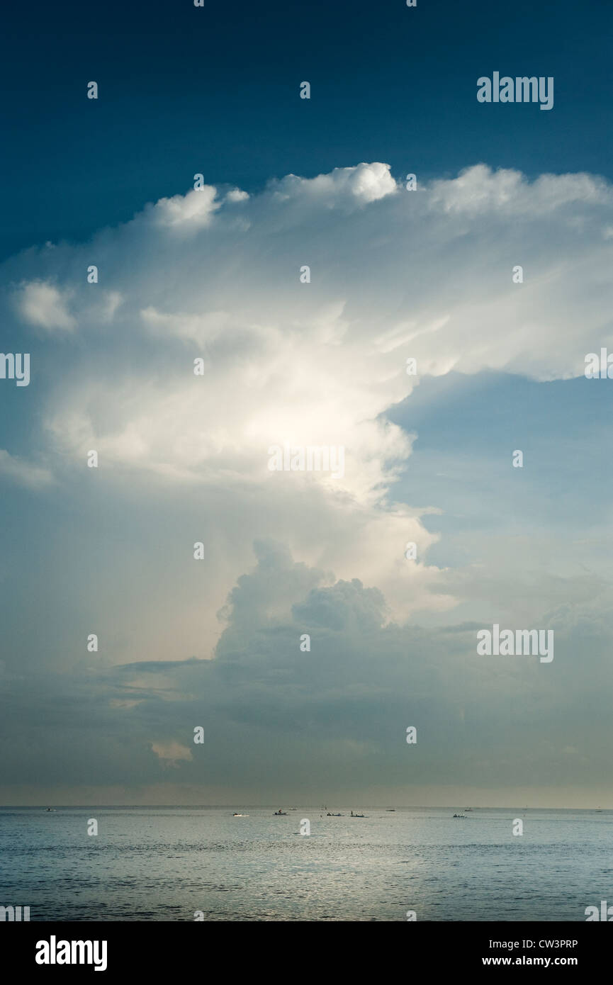 A huge thundercloud hovers over the Indian Ocean and fishing boats near ...
