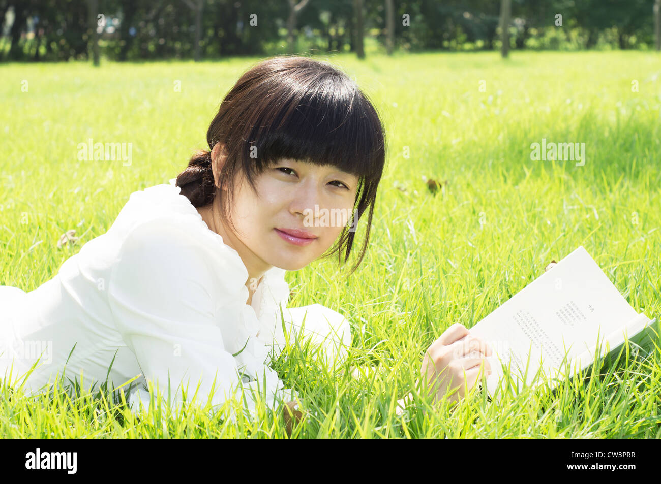 Beautiful young woman reading a book on nature Stock Photo - Alamy