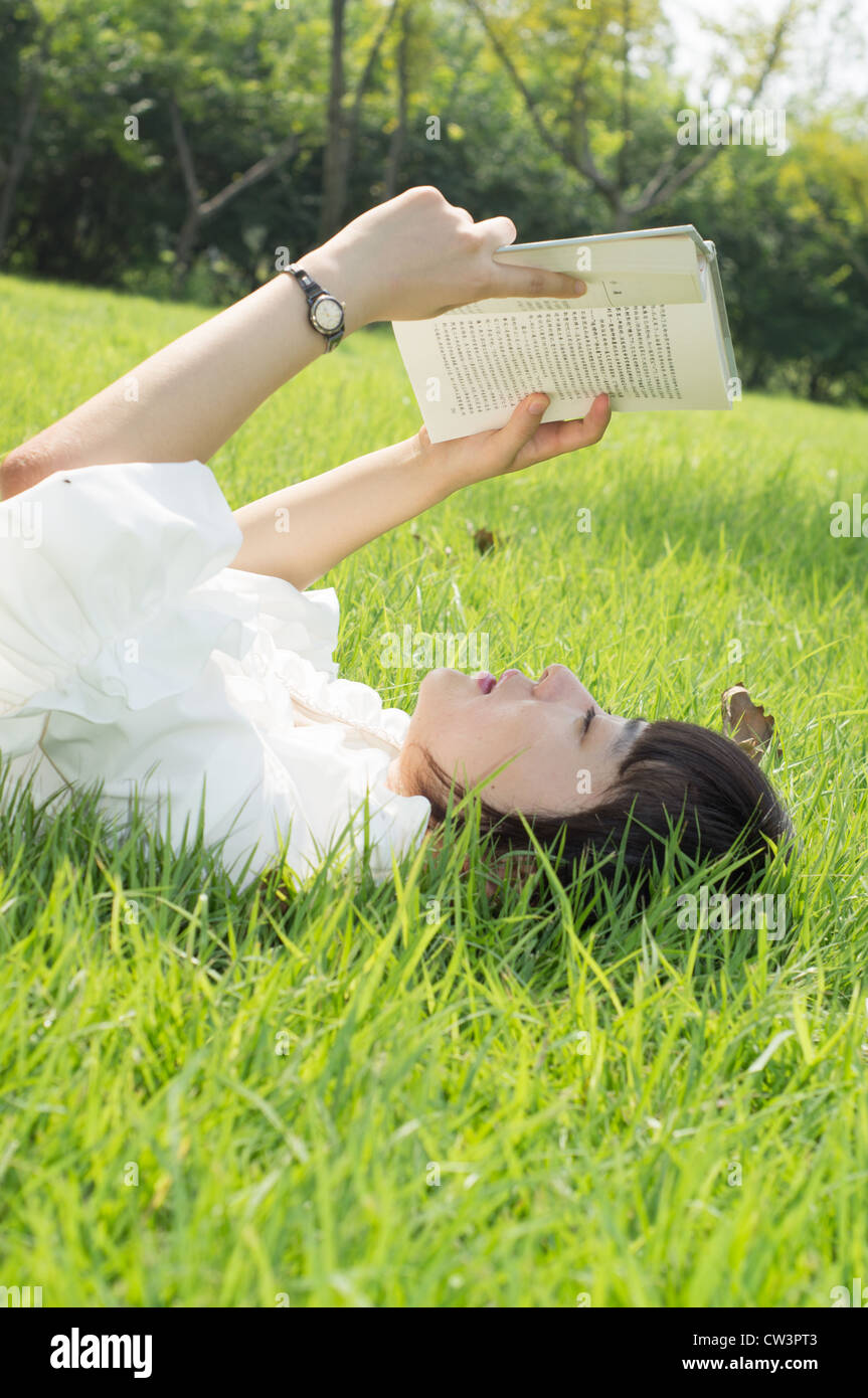 Beautiful young woman reading a book on nature Stock Photo - Alamy