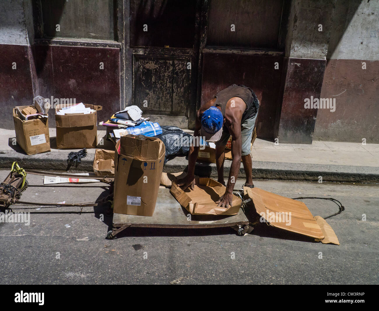 A Cuban man picks through a pile of trash looking for salvageable ...