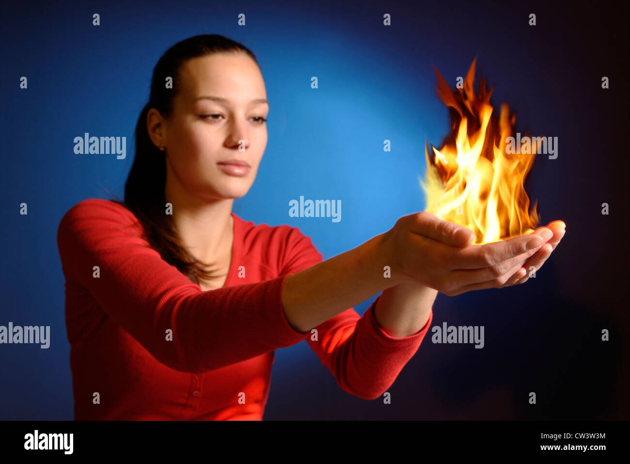 Young woman holding hands in the fire Stock Photo - Alamy