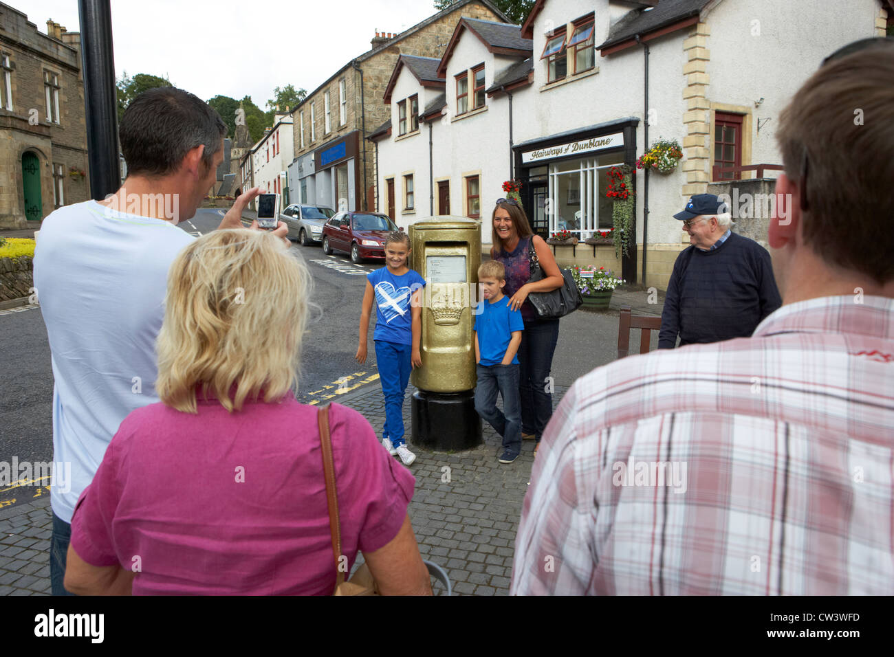 People taking photos and posing at the Dunblane postbox painted gold in ...